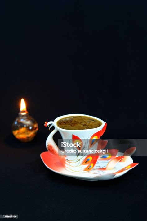 검은 색 배경과 테이블에 공작 모양의 커피 컵에 반짝이는 커피와 기름 램프를 굽기 그녀의 뒤에 서있다 0명에 대한 스톡 사진 및 기타 이미지 Istock