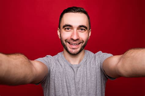 빨간색 배경 위에 고립 된 셀 카를 복용 하는 동안 행복 한 젊은 남자의 초상화 명랑한에 대한 스톡 사진 및 기타 이미지 명랑한 백인종 보여주기 Istock