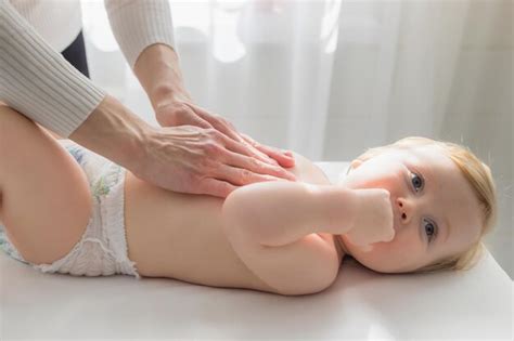 Premium Photo Mom Gives Her Baby A Tummy Massage Close Up