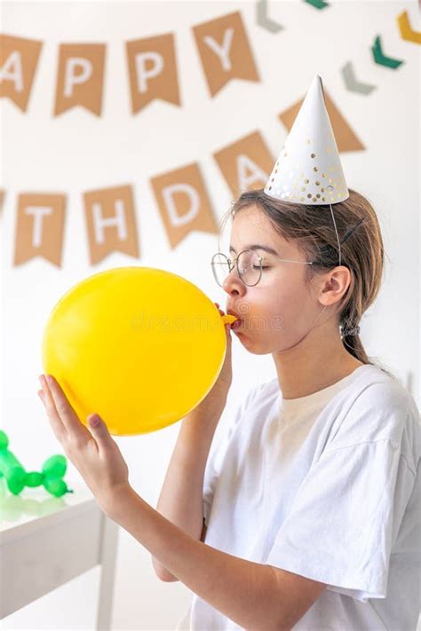 A Festive Girl Inflates A Balloon On Her Birthday Birthday Concept