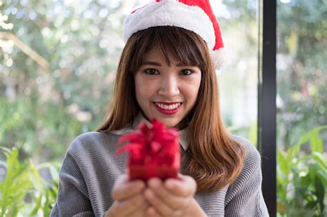 아시아 여자의 집에서 산타 클로스 모자를 착용 선물 선물 상자 소녀입니다 크리스마스 새 해 휴일입니다 메리 크리스마스 축