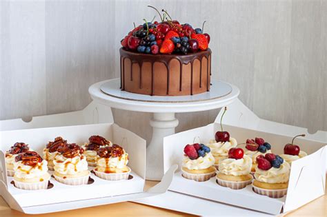 신선한 딸기 딸기 체리 블루베리로 장식된 초콜릿 케이크와 테이블에 모듬 컵케이크 상자 갈색에 대한 스톡 사진 및 기타 이미지 갈색 공휴일 과일 Istock