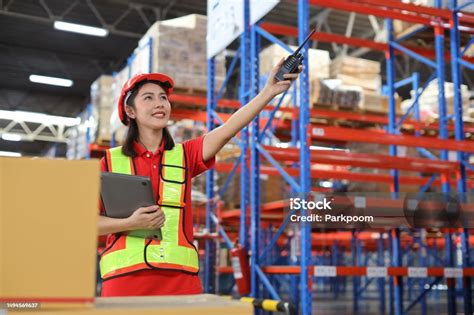 안전모와 반사 재킷을 입은 창고 노동자들은 컴퓨터를 사용하고 무전기 라디오로 무언가를 가리키며 소매 창고 물류 센터에서 재고 재고를 통제하고 있다 30 34세에 대한 스톡