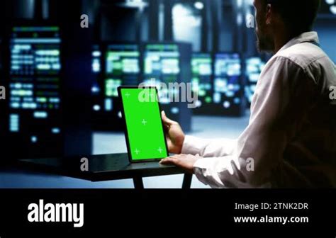 Specialist Using Green Screen Tablet To Check Server Rigs Doing Intense