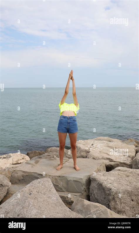 Girl In A Shirt Giving A Gymnastic Exercise On The Rocks Arching Her
