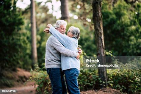 포옹과 사랑으로 야외 자연 숲을 즐기는 시니어 액티브 커플 성숙한 남자와 여자와 영원히 삶의 개념 노인과 아름다운 숲 녹색 배경 2명에 대한 스톡 사진 및 기타 이미지