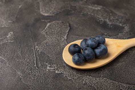 검은 질감의 배경에 나무 숟가락에 블루 베리 익은 신선한 블루 베리 비타민 건강 식품 육즙이 많은 베리 공간을 복사합니다 텍스트 위치 0명에 대한 스톡 사진 및 기타 이미지