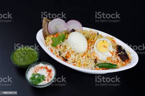 라이타 또는 커드 또는 요구르트와 검은 배경에 고립 된 녹색 고수 처트니와 흰색 타원형 그릇에 제공 된 흰 삶은 달걀 비리야니 0명에 대한 스톡 사진 및 기타 이미지