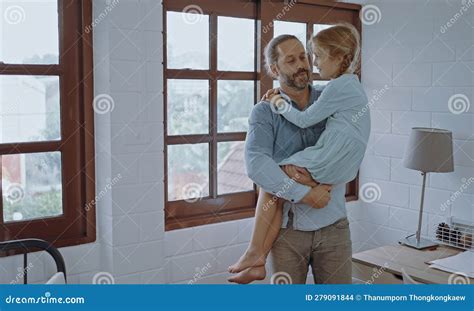 Padre Cargando Y Abrazando A Su Hija En Casa Foto De Archivo Imagen