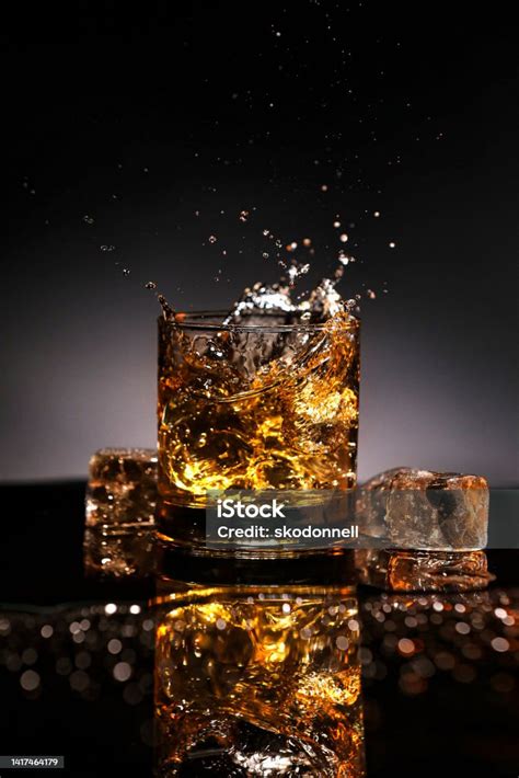 버번 위스키 또는 럼이 얼음으로 유리에서 튀어 나오다 블랙 리플렉션의 큐브 위스키에 대한 스톡 사진 및 기타 이미지 위스키 위스키 잔 버번 위스키 Istock