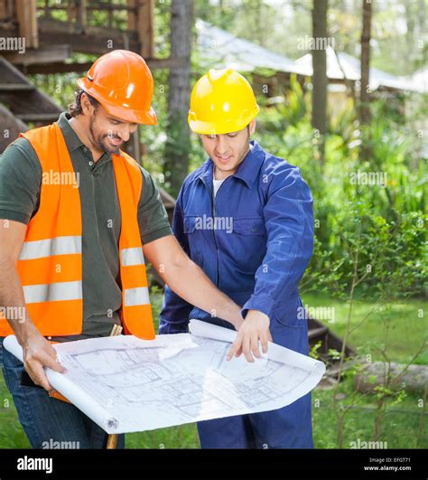 Architects Discussing Over Blueprint Construction Hi Res Stock