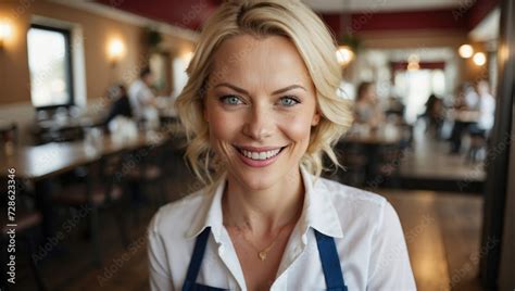 Smiling Blonde Woman With Blue Eyes Wearing A Waitress Apron In A