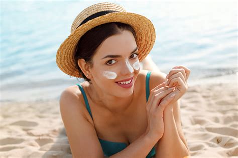 검게 그을린 얼굴에 크림 자외선 차단제를 바르는 아름 다운 여자 선스크린 피부와 바디 케어 소녀는 피부를 위해 자외선 차단제를 사용합니다 30 34세에 대한 스톡 사진 및