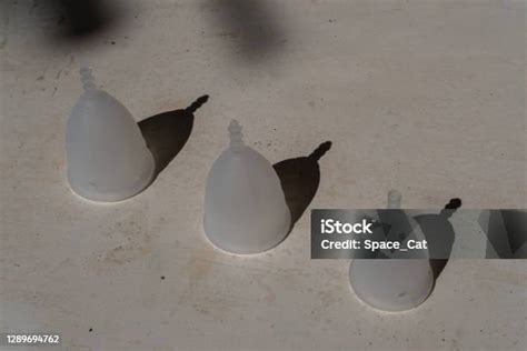 어두운 그림자와 미니멀 한 배경에 실리콘 생리 컵의 다른 크기 재사용 가능한 친환경 여성 위생 제품 제로 폐기물 지속 가능한