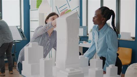 Team Of Multi Ethnic Women Analyzing Maquette On Table To Design Building Model Stock Video