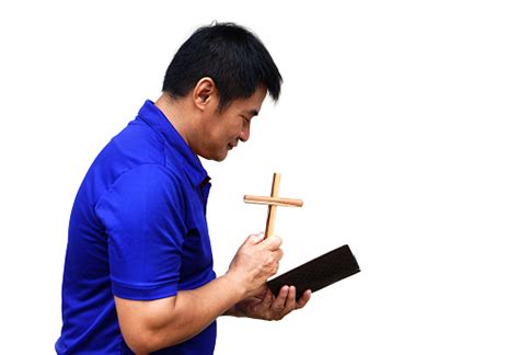 크리스챤 아시아 남자가 기도하고 나무 십자가와 책을 들고 있습니다 흰색 배경에 고립되어 있습니다 개념 기독교 예배 믿음 용서