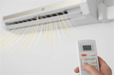 Premium Photo Man Operating Air Conditioner With Remote Control Indoors Closeup