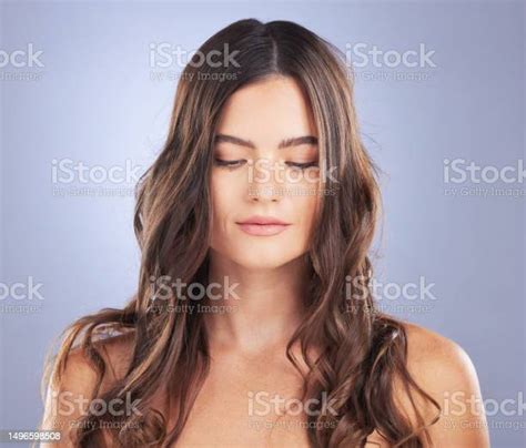 여성 미용 헤어 케어는 파란색 배경에 컬 성장 건강한 빛을 위해 스튜디오에서 활동한다 미용실이나 미용사를 위한 헤어케어 자기애 화장품을 위한 미적 여성 모델 얼굴 결과 긴