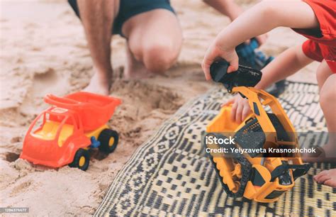 아버지의 날 아빠와 아들 작은 아들은 모래와 해변에서 아빠와 장난감을 한다 행복한 사랑의 가족 행복한 가족 아버지와 아이 장난감 자동차 해변에서 남자와 작은 아이의 손 함께