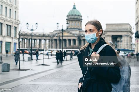 2020 년 유럽에서 검역 코로나 바이러스 발생 방지 도시 거리에서 마스크를 쓰고 젊은 유럽 여성의 초상화 오염 및 질병 개념을