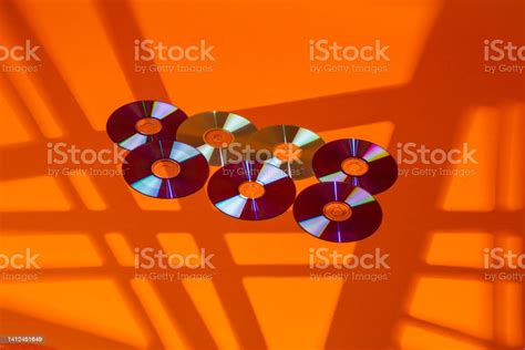 다양한 직사각형 광선 패턴 또는 마스크를 사용하여 주황색 배경에 배열 된 Cd 디스크 또는 Dvd 디스크의 다양성 0명에 대한 스톡 사진 및 기타 이미지 Istock