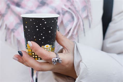 벙어리 장갑을 낀 여자가 뜨거운 음료가 담긴 종이컵을 들고 있다 겨울에 마시는 따뜻한 음료 12월에 대한 스톡 사진 및 기타