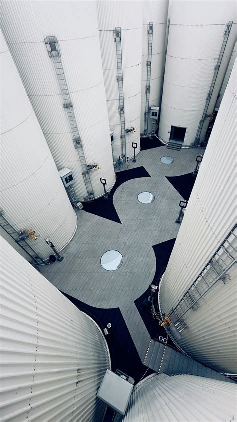 거대한 구조물 건축 곡물 저장 골이 진 공장 공중 공중 촬영 금속 금속 표면 기하학적 기호 논리학 농촌의 대칭 대형 사일로 도시의 등산하다