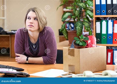 Thoughtful Woman Sitting In The Office With The Collected Things Stock