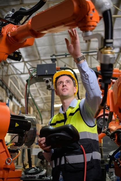 Premium Photo A Male Worker Is Controlling A Welding Robot By Using Forcing Welding With A