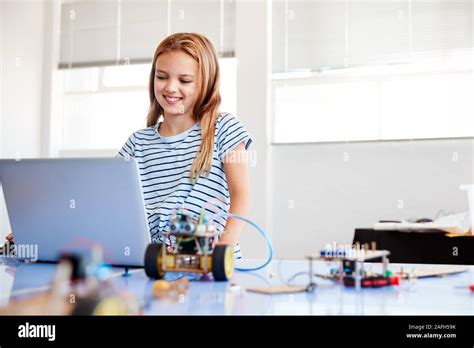Female Student Building And Programing Robot Vehicle In After School