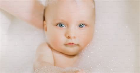 거품 거품을 가지고 노는 목욕을 하는 행복한 웃는 아기 욕조에 있는 어린 아이 유아 씻기 및 목욕 어린 아이들을위한 위생 및 보살핌 신생아 목욕 사진