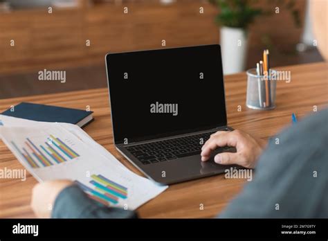 Mature Asian Male Typing On Laptop Keyboard With Empty Screen Works