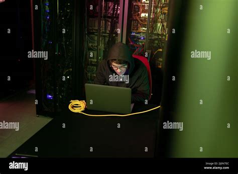 Asian Male Hacker Using A Laptop In Computer Server Room Stock Photo Alamy