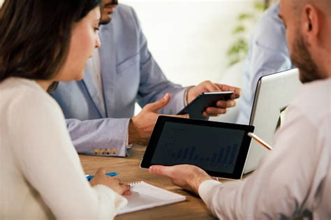 회의 중에 디지털 태블릿에서 그래프를 검토하는 비즈니스 동료 두 명 20 24세에 대한 스톡 사진 및 기타 이미지 20 24