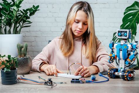 A Teenager Girl Plugging Cables To Sensor Chips While Learning Arduino