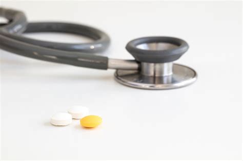 흰색 배경에 고립 된 청진기와 흰색과 노란색 색상 알약의 클로즈업 건강 검진에 대한 스톡 사진 및 기타 이미지 건강 검진 건강 진단 건강관리와 의술 Istock