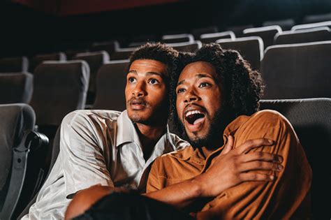 A Couple Is Scared In The Cinema While Watching A Horror Movie Stock