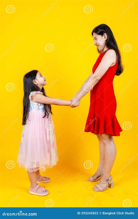 Asian Mom And Daughter Taking Portrait Photo Together On Yellow