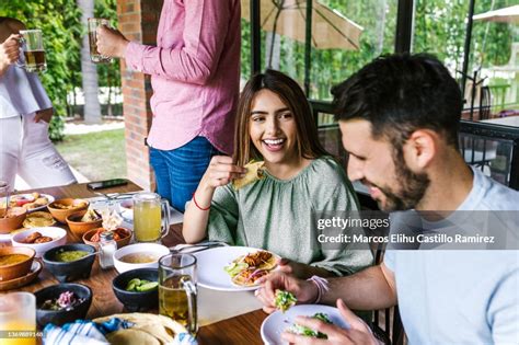 Group Of Latin Friends Eating Mexican Food In The Restaurant Terrace In