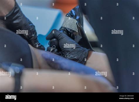 Tattoo Artist At Work Visible Hands In Black Gloves Holding Tattoo Gun