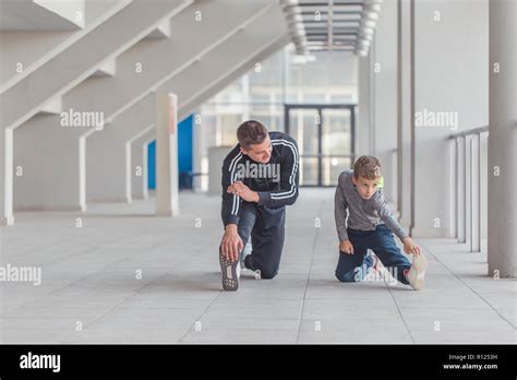 Little Boy And His Father Stretching Leg Together At A Sports Center