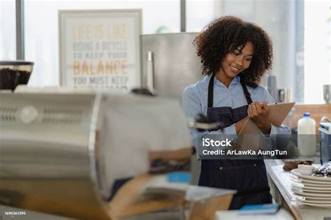 커피 바에서 아름 다운 젊은 라틴 아메리카 바리 스타 아늑한 로프트 스타일의 카페 음식과 음료 개념의 카운터에서 일하는 남성