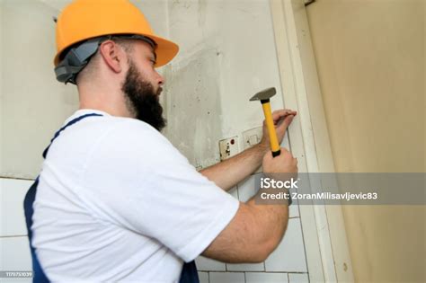 건설 노동자와 정비 공사중의 핸디맨 노란색 망치 파업과 건설 현장에서 부엌 문 나무 벽에 못을 박는 빌더 아파트 리노베이션 개념입니다 개발에 대한 스톡 사진 및 기타 이미지