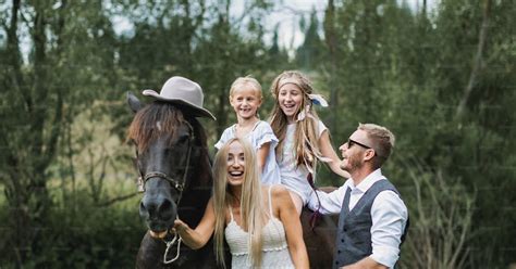 행복한 가족 부모와 자녀 말의 존재를 즐기고 있습니다 소녀들은 모자를 쓰고 말을 타고 있습니다 남자와 여자 부모는 재미 있고 웃고 있습니다 시골 야외 승마 사진