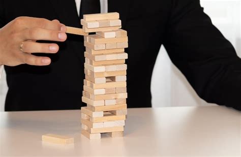 Premium Photo Businessman Builds A Tower With Toy Pieces