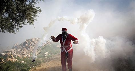 최루탄 던지는 산타클로스 복장의 팔레스타인 시위 남성