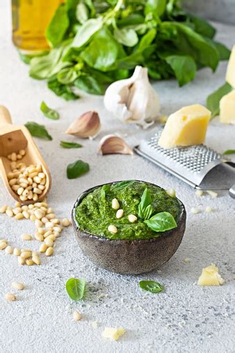녹색 페스토신선한 바질 잎 소나무 견과류 파마산 마늘과 올리브 올리아로 만든 그릇에 가벼운 배경에 샐러드 파스타 피자를 위한 인기 있는 이탈리아 드레싱 건강한 식생활에 대한