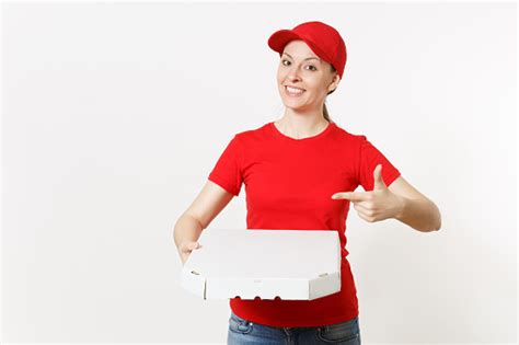 흰색 배경에 고립 된 빨간 유니폼에 배달 여자 꽤 여성 모자 티셔츠 청바지 택배 또는 골 판지 Flatbox에서 이탈리아 피자를 들고 딜러로 일하고 광고에 대 한 공간을