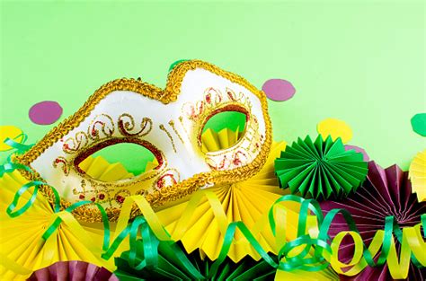 복사 공간 인사말 카드 및 카니발 또는 생일파티 초대 템플릿 디자인 마디 그라 녹색 배경에 다채로운 종이 색종이 카니발 마스크와 색깔의 뱀 Mardi Gras에 대한 스톡