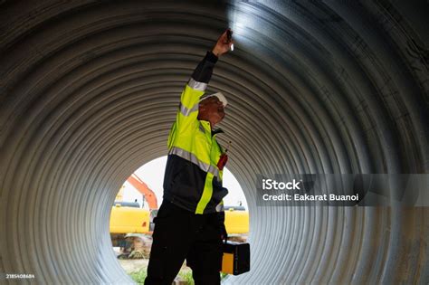 남녀 엔지니어가 대형 강관 내부를 검사합니다 작업자들은 산업 플랜트에서 석유 천연 가스 및 연료를 운송하기 위한 파이프라인을